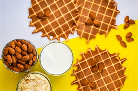 유리에 아몬드 너트와 아몬드 칩과 아몬드 우유를 흰색과 노란색 배경 복사 공간 상단 보기에 유리에 수제 와플 0명에 대한 스톡 사진 및 기타 이미지 Istock