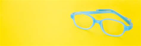 밝은 노란색 테이블 배경에 부드러운 고무 프레임이 있는 아기 파란색 안경입니다 근접 촬영 와이드 배너 텍스트를 위한 빈 공간입니다 정면 View 0명에 대한 스톡 사진 및
