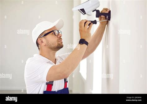 Worker Installing A Surveillance Cctv Camera On The Wall Inside The