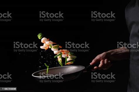 해산물 요리사가 새우를 포드 콩과 브뤼셀 콩나물을 프라이팬과 프라이팬에 넣습니다 디자인 메뉴 레스토랑 동양 요리 건강한 음식에 대한 검은 배경에 고급 요리에 대한 스톡 사진