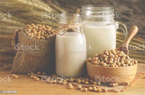 유리 병에 콩 우유와 나무 그릇에 마른 씨앗과 부드러운 밝은 갈색 빈티지 톤으로 건강한 음식 개념을 위해 흐림 밀 귀 배경에 자루 가방 우유에 대한 스톡 사진 및 기타