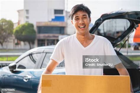 개인 차를 통해 고객에게 골판지 상자를 제공하는 행복한 아시아 남자의 클로즈업 사람들의 라이프 스타일과 비즈니스 직업 개념 캐주얼 한 옷을 입은 젊은 남성 택배 배송 및