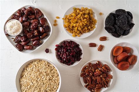 건강 한 유기농 에너지 공을 준비 하기 위한 재료날짜 말린 살구 귀리 플레이크 건포도 말린 크랜베리 피칸 견과류 흰색 바탕에 코코넛 부스러기 0명에 대한 스톡 사진 및 기타