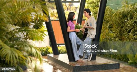 인도의 행복 한 십대 소년 어쿠스틱 기타를 연주하는 소녀 노래를 부르는 함께 서서 야외 공원 정원 Z세대 청년 커플 쌍 리허설 음악 즐기기 즐거운 즐거움 낭만적 인 데이트