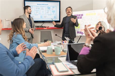 다양한 비즈니스 팀이 현대 사무실에서 창의적인 회의에서 비즈니스 모델 캔버스 프레젠테이션을 사용하여 창업 전략을 논의하고 있습니다 20 24세에 대한 스톡 사진 및 기타