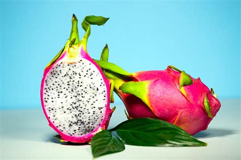 푸른 배경에 신선한 유기농 드래곤 과일의 두 절반 창조적 인 여름 음식 개념 복사 공간 배너 배경 미니멀리즘 트렌디 한 음식 다채롭고 맛있는 피타하야 0명에 대한 스톡 사진