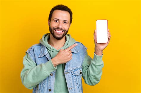 젊은 잘생긴 프로모터 남자 양복 조끼 직접 손가락 메뉴 광고 추천 전화 노란색 배경에 고립된 사진 Brand Name Smart