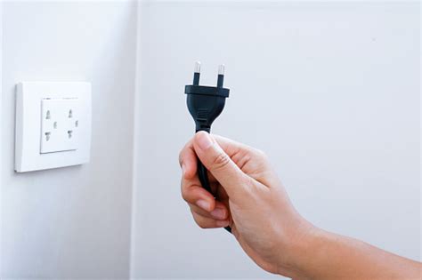 핸드 홀딩 플러그는 전원 플러그를 벽의 전기 콘센트 전원 콘센트 소켓 절전 개념 에너지 절약 에너지 절약에 연결할 준비를합니다