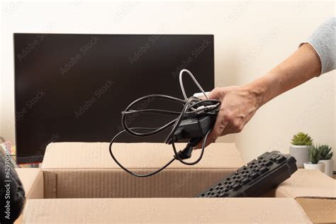 Female Hands Put Old Keyboard And Chargers In Box With Old Used Computers And Gadget Devices For