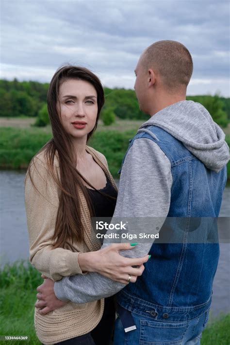 호수와 녹색 잔디 근처 야외에서 행복한 젊은 부부 대머리 남자와 갈색 머리 여자 남편과 아내 밀레니엄 세대 성공적인 결혼 진정한 사랑 2명에 대한 스톡 사진 및 기타 이미지