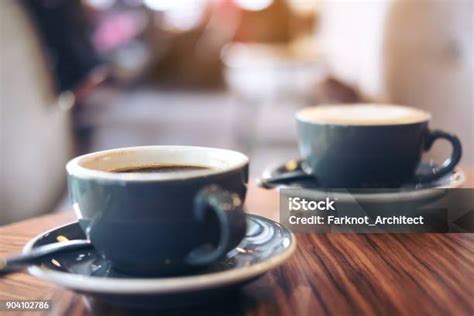 뜨거운 라 떼 커피와 아메리카 노 커피 카페에서 빈티지 나무 테이블에 두 개의 파란색 컵의 근접 촬영 이미지 갈색에 대한 스톡