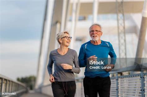 쾌활한 활동적인 시니어 커플이 다리에서 야외에서 함께 조깅을합니다 노인을위한 건강한 활동 운동에 대한 스톡 사진 및 기타 이미지 Istock