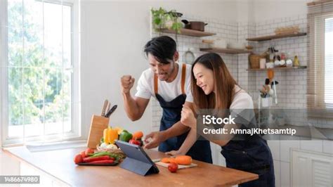 온라인 요리 수업의 성공적인 완료를 축하하는 팔을 들고 있는 행복한 아시아 커플 2명에 대한 스톡 사진 및 기타 이미지 2명 가정 주방 가정의 방 Istock