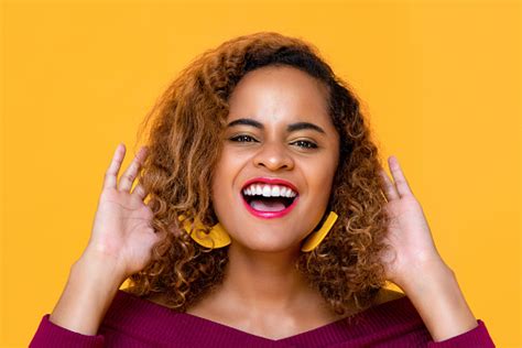 고립 된 스튜디오 노란색 배경에서 두 손을 귀 주위에 컵 화 유행 외관에 미소 행복 젊은 아름다운 아프리카 계 미국인 여성의