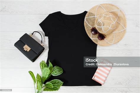 T 셔츠 블랙 여름 액세서리와 T 셔츠 목업 플랫 레이 나무 바닥 배경에 모자 가방 선글라스 공간을 복사합니다 템플릿 빈 캔버스입니다 전면 상단 뷰입니다 0명에 대한 스톡