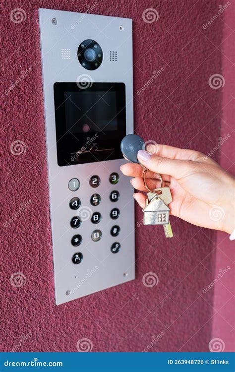 A Young Woman Types The Apartment Code On The Electronic Intercom Panel