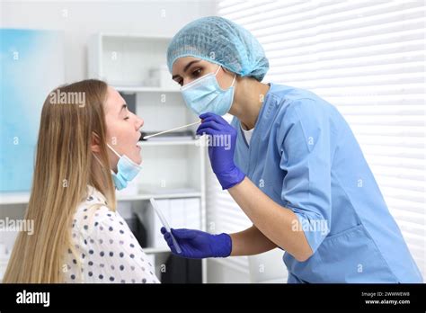 Laboratory Testing Doctor Taking Sample From Patients Mouth With Cotton Swab In Hospital Stock