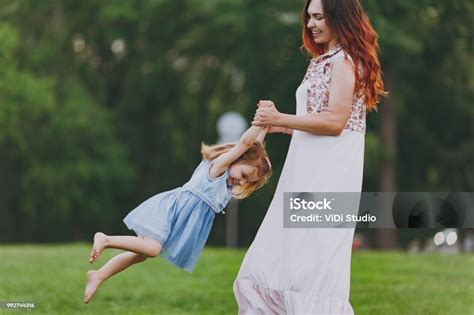 빛 드레스에 여자와 귀여운 아이 아기 소녀 주위에 공원에서 푸른 잔디 잔디밭에 돌고 재생 미소 어머니 딸 아이입니다 어머니의 날 사랑 가족 부모 어린 시절 컨셉 2명에 대한