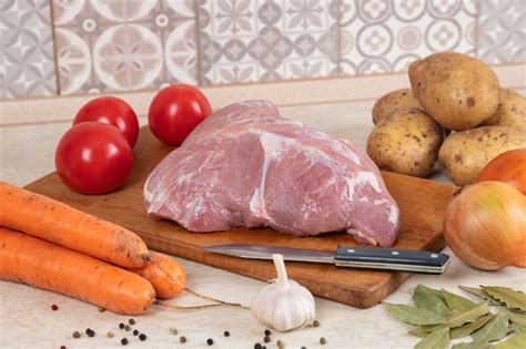 부엌의 식탁에 있는 원재료 고기와 함께 삶은 감자를 요리합니다 고기 감자 당근 파슬리 마늘 돼지고기 파슬리를 곁들인 수프 멀티 쿠커에서 요리하기 0명에 대한 스톡 사진 및