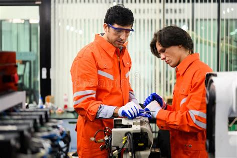 Engineers Working And Solving Problems On Machine At Industrial Plant