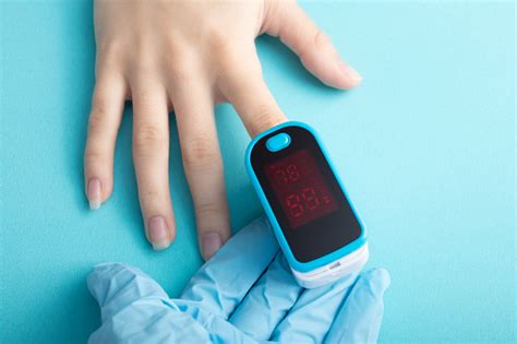 혈액의 산소 포화도를 측정하기위한 의료 기기 의사가 파란색 배경에서 환자를 측정합니다 감지기에 대한 스톡 사진 및 기타 이미지 감지기 건강관리와 의술 사고와 재해