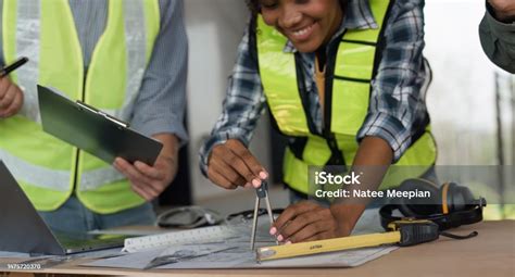 건축 계획을 위한 청사진을 작업하는 건축가 팀 작업 현장의 테이블에 건설 프로젝트를 스케치하는 엔지니어 3 명에 대한 스톡 사진