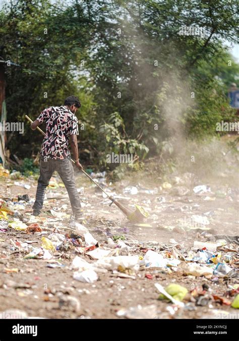 Man Sweeping The Trash With Broom And Polyhthene Big Garbage Area Man Cleaning The Polluted