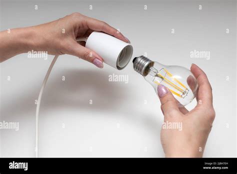 Woman Screwing A Lamp Into A Socket Stock Photo Alamy