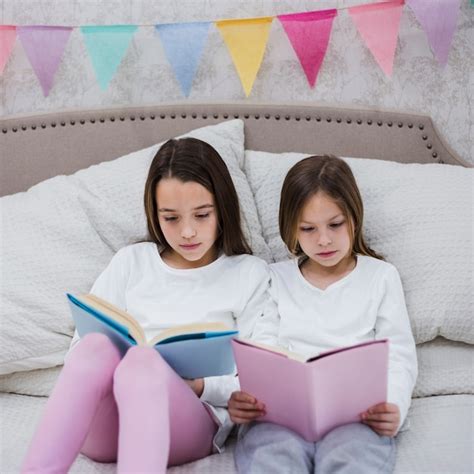 Free Photo Sisters Reading Book Together