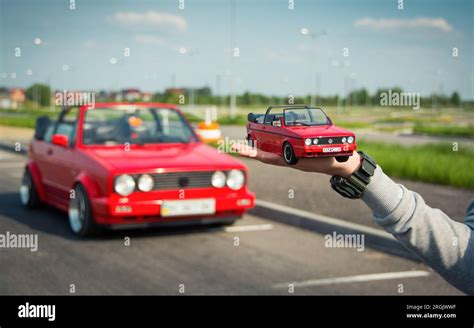 Hand On The Left Holding A Toy Red Volkswagen Golf Mk2 Cabriolet And
