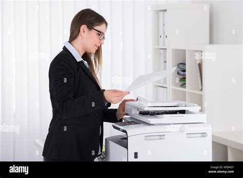 Businesswoman Using Copy Machine Stock Photo Alamy