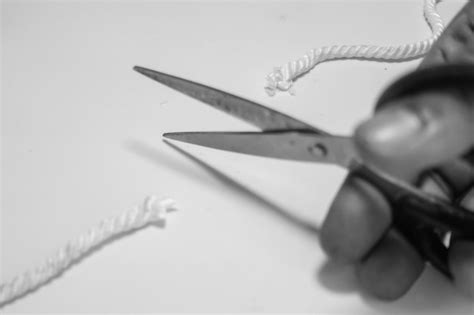 Premium Photo A Pair Of Scissors Are Being Used To Cut A Strand Of