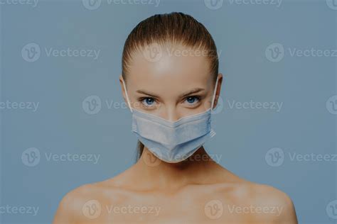 Studio Shot Of Naked European Woman Wears Disposable Medical Mask As Prevention Fromm