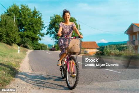 화창한 여름 날 에 젊은 여자 를 입고 드레스 를 타고 자전거 자전거를 타고 열린 도로 트로프 마을 거리에 대한 스톡 사진 및 기타 이미지 Istock