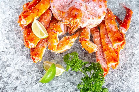 큰 빨간 캄차카 게 얼음에 거짓말 발톱 체리 레몬과 라임의 조각은 둥근 슬라이스 주위에 거짓말 신선한 허브와 함께 빛 상단 측면보기 주위 Washoku에 대한 스톡 사진 및