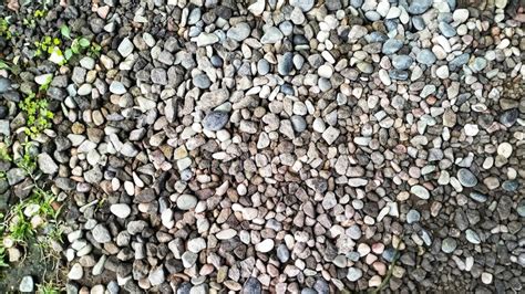 Colorful Pebbles Rock Texture With Green Grass On The Side Background