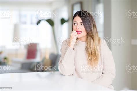젊은 아름 다운 여 자가 입에 물고 손톱에 손으로 스트레스와 긴장을 찾고 겨울 스웨터를 입고 불안 문제 가정 생활에 대한 스톡 사진 및 기타 이미지 Istock