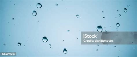 흰색 유리에 빗방울이 있는 최소한의 조명 배경 비오는 물방울이 있는 가벼운 젖은 창문이 푸른 빛으로 근접 촬영됩니다 빗방울이 있는 창 유리의 흐릿한 미니멀리스트 흑백 배경이