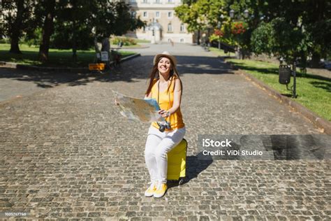 즐거운 여행자 관광 여자 노란색 옷 모자 야외 시에서 도시 지도 검색 경로 들고 가방에 앉아 여자도 주 주말에 여행을 해외 여행입니다 관광 여행 생활양식입니다