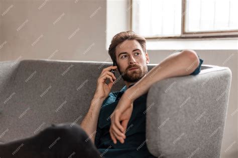 Premium Photo Portrait Of Young Man On The Phone Sitting On Couch