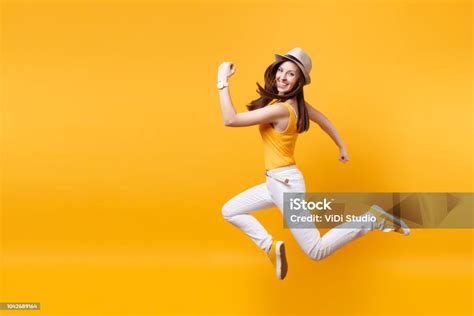 흥분된 웃는 영 행복의 노란색 오렌지 배경에 고립 된 공간을 복사 밀 짚 여름 모자 높은 여자를 점프 합니다 사람들이 진심으 감정 열정 라이프 스타일 개념 광고 영역입니다
