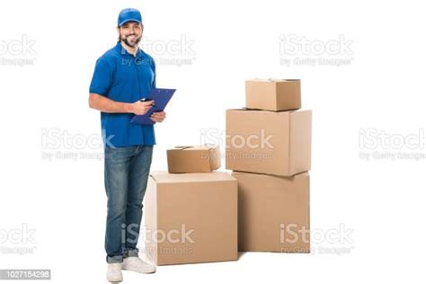 클립보드를 들고 상자 근처 서 흰색 절연 하는 동안 카메라에 웃 고 잘생긴 젊은 배달 노동자의 전체 길이 보기 배달부에 대한 스톡 사진 및 기타 이미지 Istock