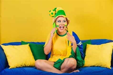 Premium Photo Caucasian Woman Redhead Brazil Soccer Fan Brazilian On Couch Chatting On Smartphone