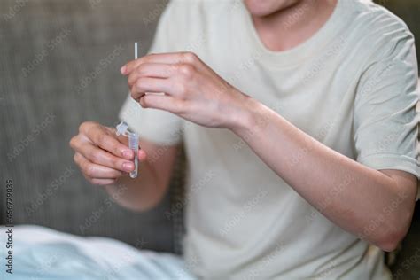 Asian Woman Using Rapid Antigen Test Kit For Self Test COVID 19 Epidemic At Home Adult Female