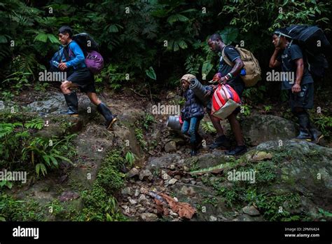 Migrants From Ecuador And Nigeria Walk Through A Rocky Trail In The