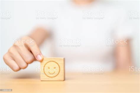 고객 리뷰 좋은 경험 긍정적인 피드백 만족도 설문 조사 평가 평가 기분 및 세계 정신 건강의 날 개념을 위해 감정 블록에서 행복한 얼굴을 선택하는 손 Mental