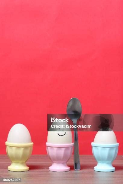 다진 껍질을 다진 삶은 달걀이 데친 안에 서 있습니다 계란에 웃는 그린 근처에는 음식과 빈 Pashotnitsy에 대한 숟가락이있다 산호 색상의 배경에 대해 갈색에 대한