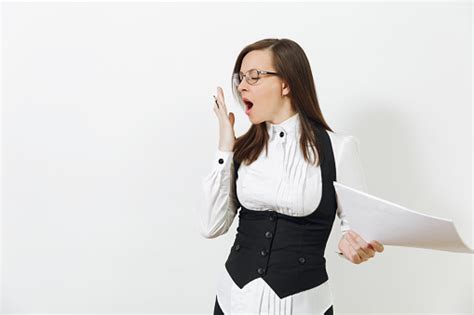 검은 양복 흰 셔츠와 흰색 배경에 고립 하 품 하는 작업 문서와 안경에 피곤된 졸린 백인 젊은 갈색 머리 비즈니스 여자 관리자 또는 작업자 합니다 광고에 대 한 공간을 복사