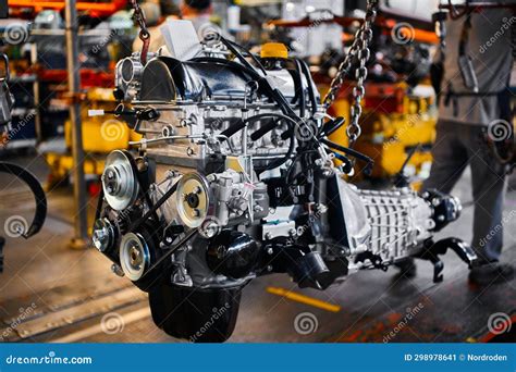 Car Motor Hangs On Chains In Assembling Plant Workshop Stock Image