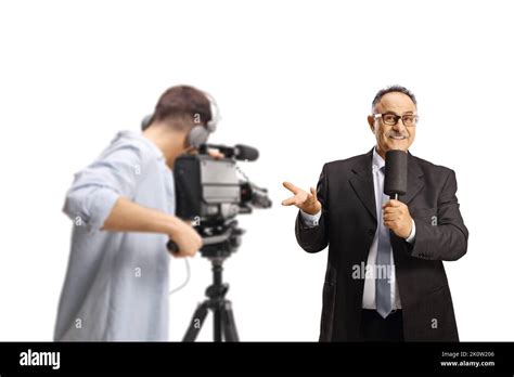 Cameraman Recording A Male Tv Host With A Microphone Gesturing With